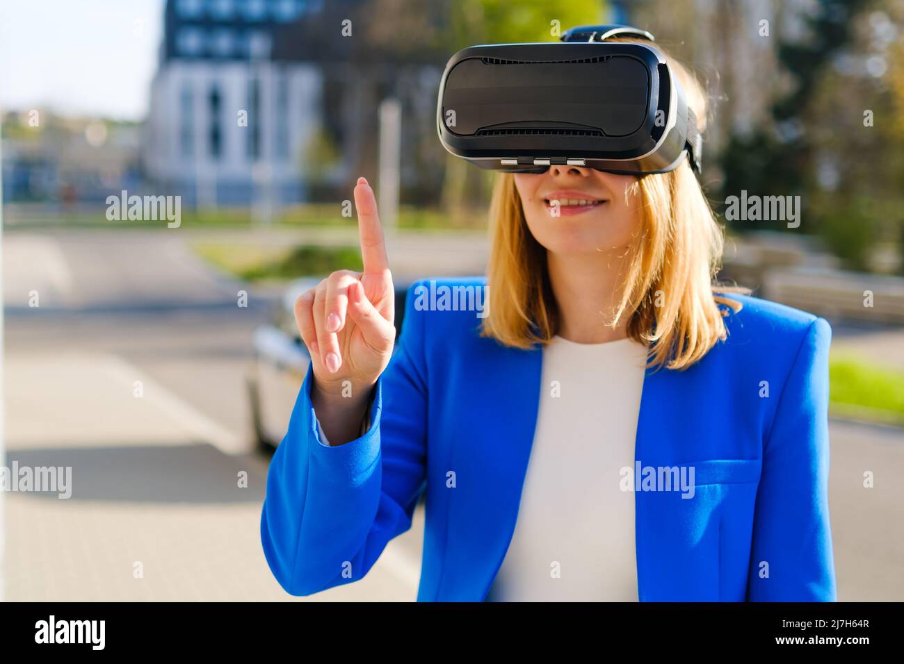 A happy woman in the suit is standing outside and gestures in augmented ...