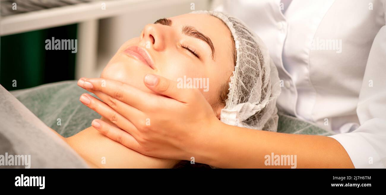 Facial Massage Hands Of A Masseur Massaging Neck Of A Young Caucasian