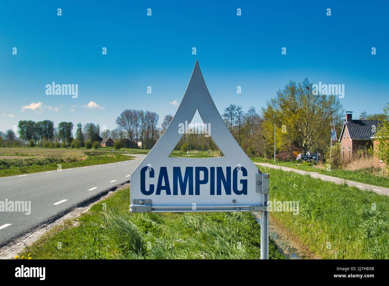Sign in the shape of a tent, indicating a campground along a rural road ...