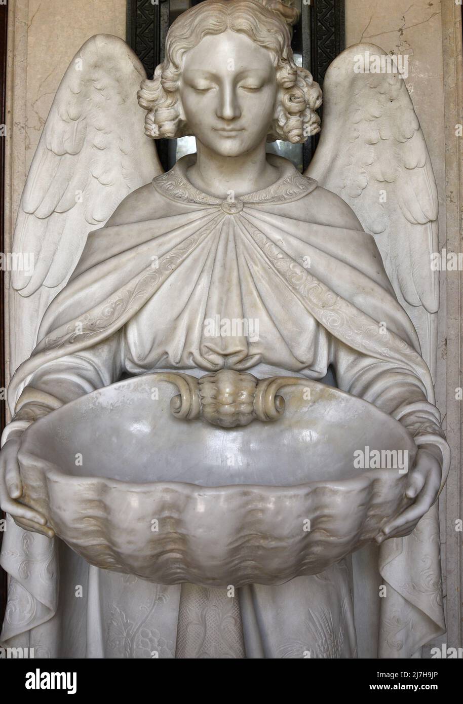 A marble holy water font in the form of an angel at the entrance to the ...