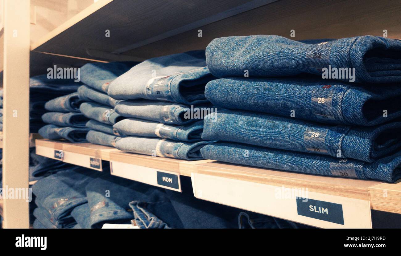 assortment of blue jeans on wooden shelves Stock Photo - Alamy