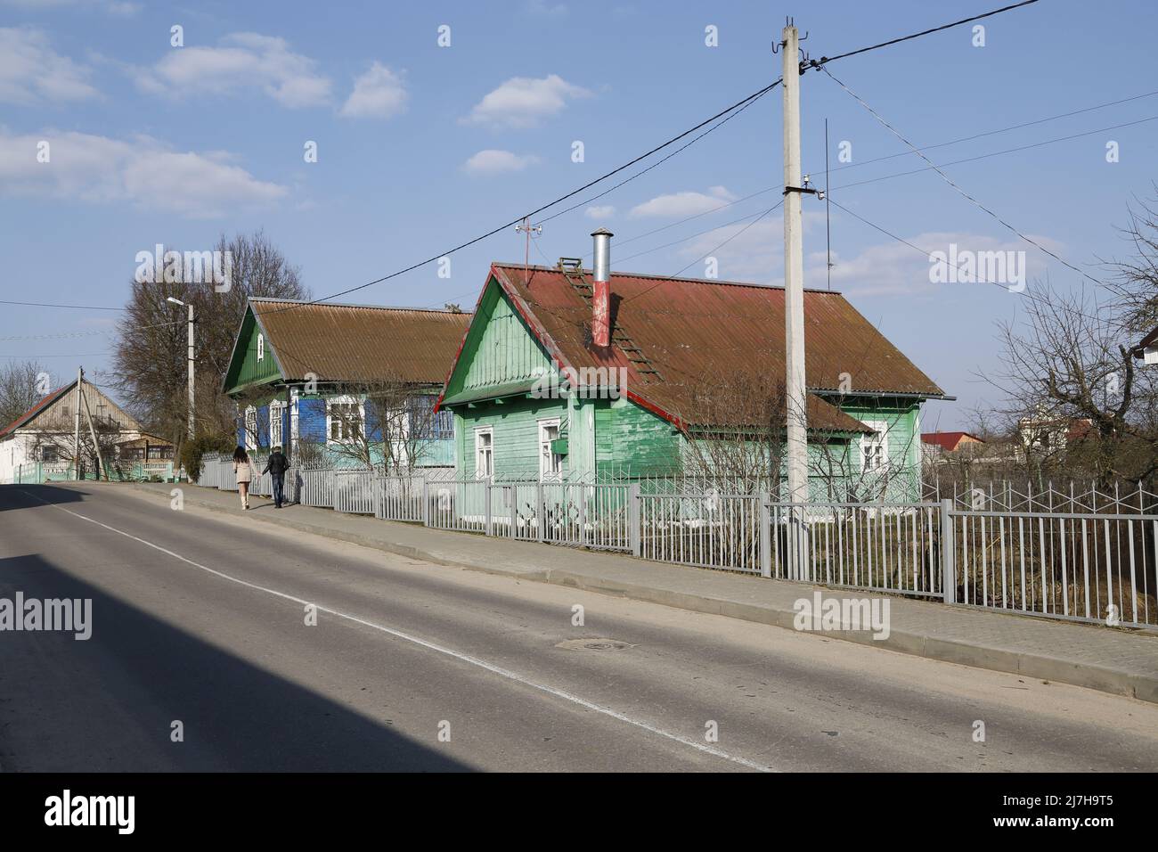 Traditional wooden houses along a road in a village in Belarus Stock ...