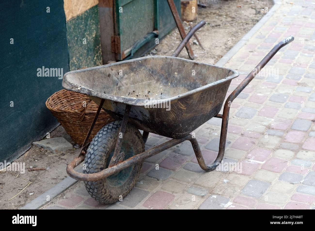 An empty wheelbarrow for garden with one wheel is standing on the ...
