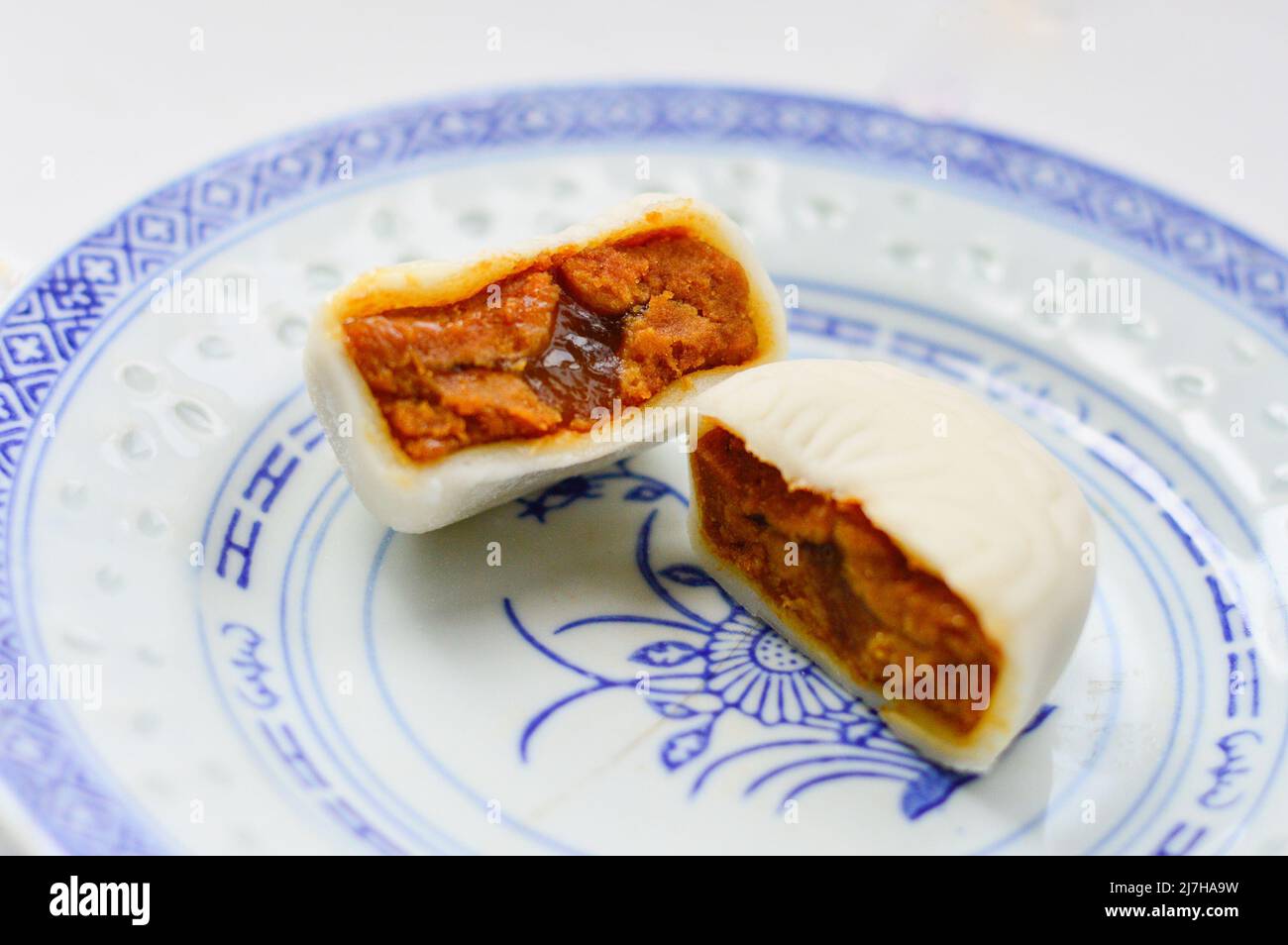 The half-opened Chinese snowy moon cake on a plate, showing yolk ...