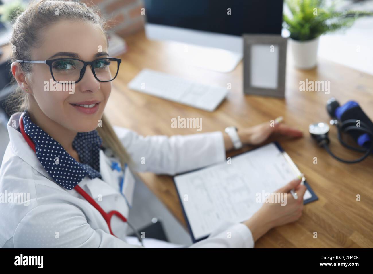 Doctor fill in patients medical history, stethoscope on neck, modern ...