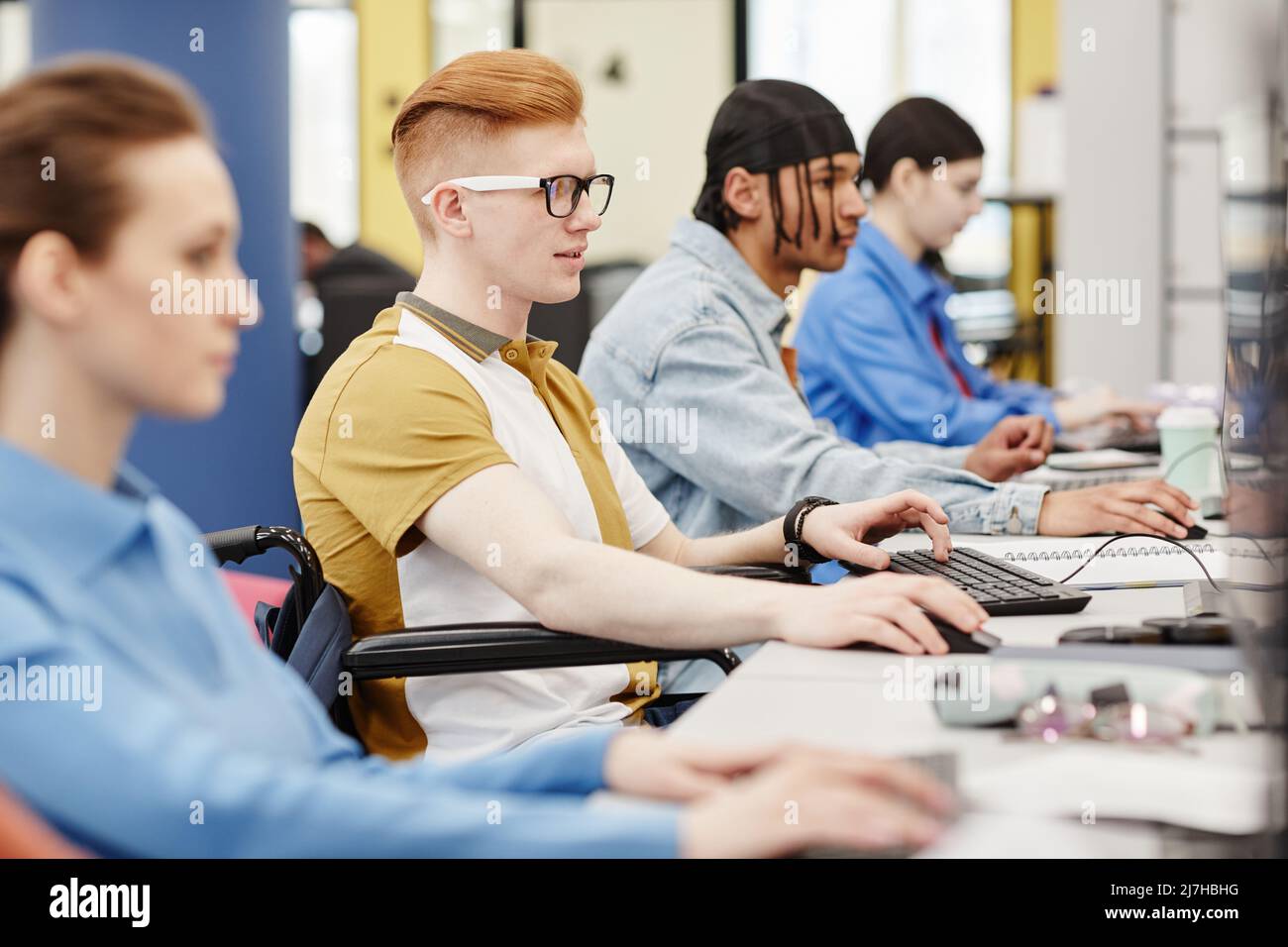 Vibrant side view shot of young college student with disability using ...