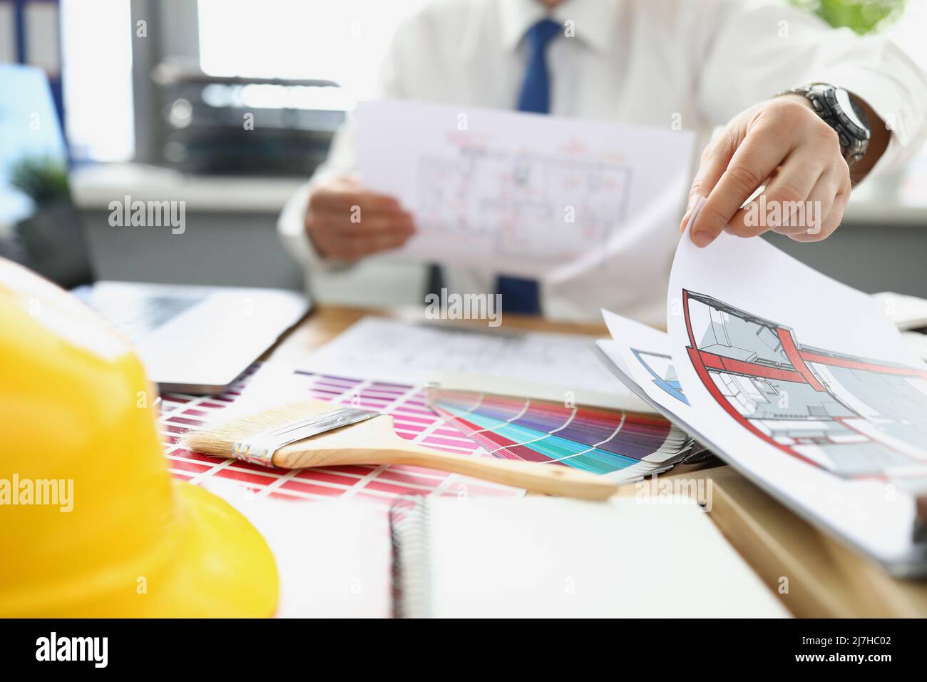 Successful designer work on new project, palette on desk, house plan ...