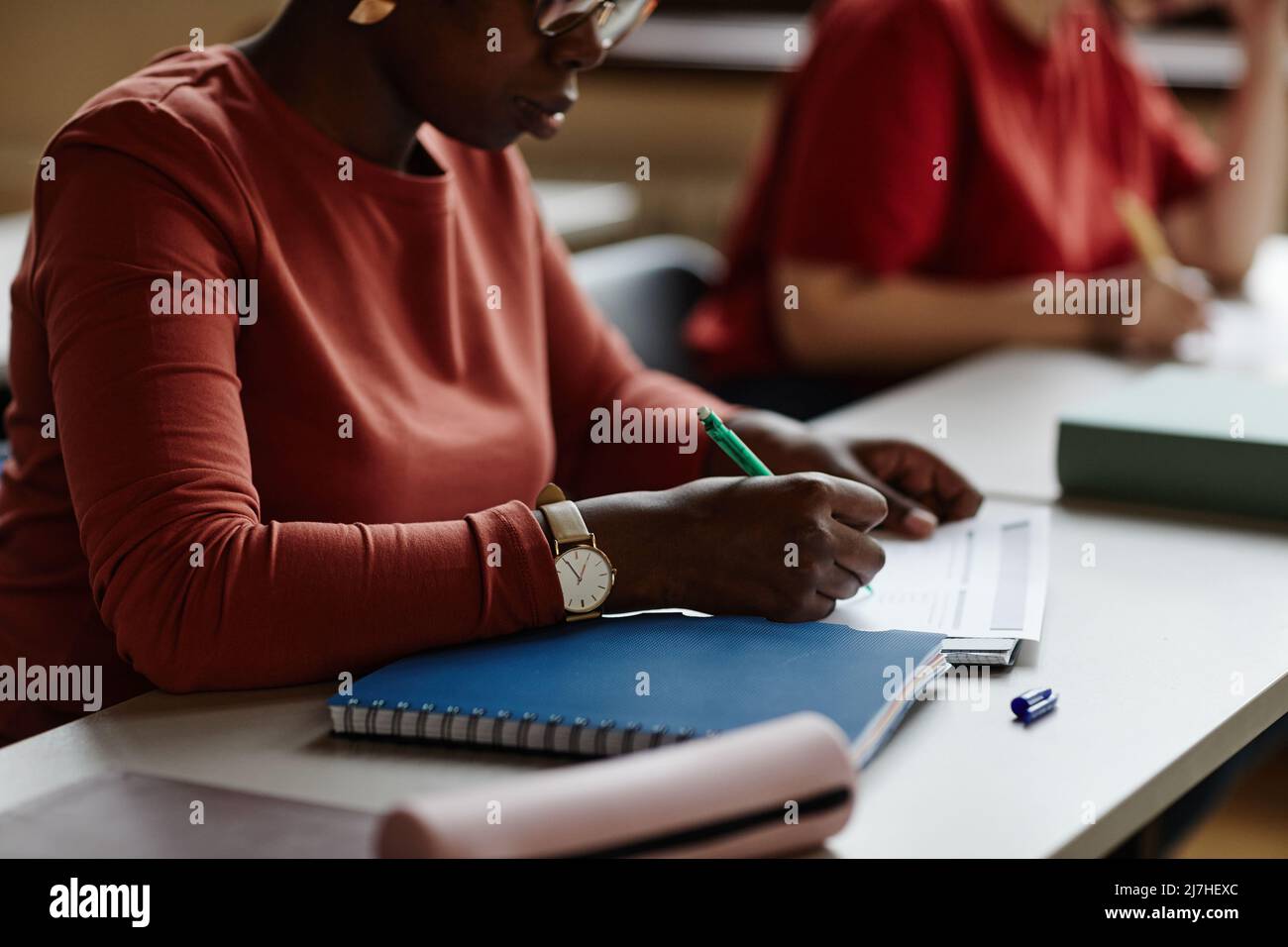 Closeup of African American young woman taking notes while studying at ...