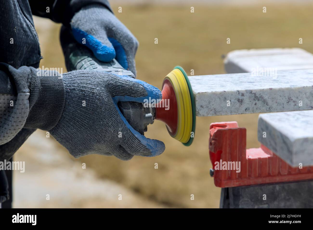 Master use a sander tool for polished granite stone Stock Photo - Alamy