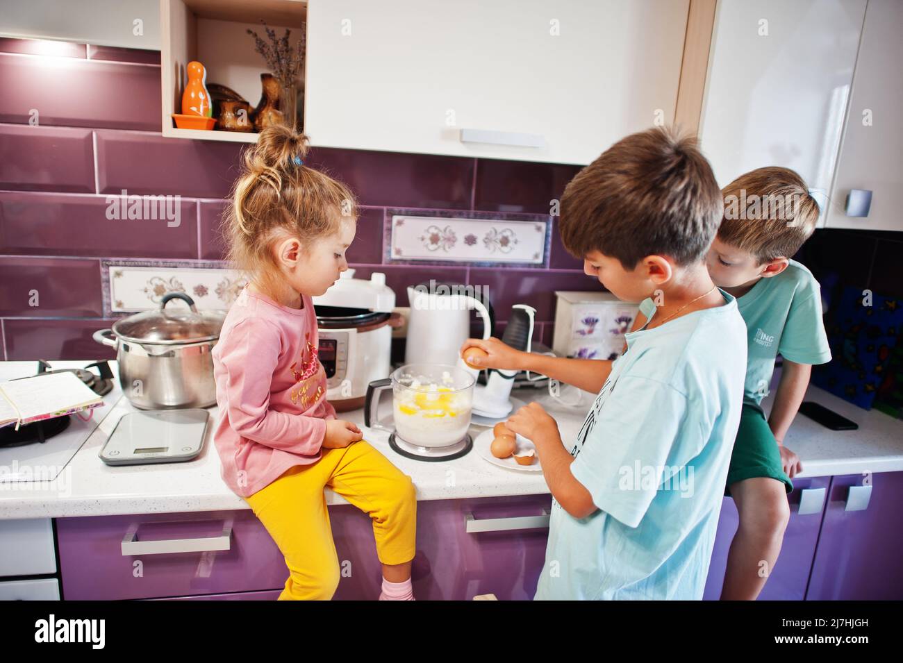 Kids cooking at kitchen, happy children's moments. Crack an egg Stock ...