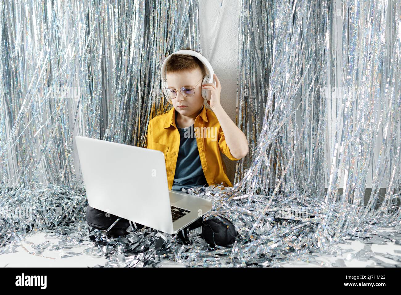 child boy in headphones with laptop on party background. Kids ...