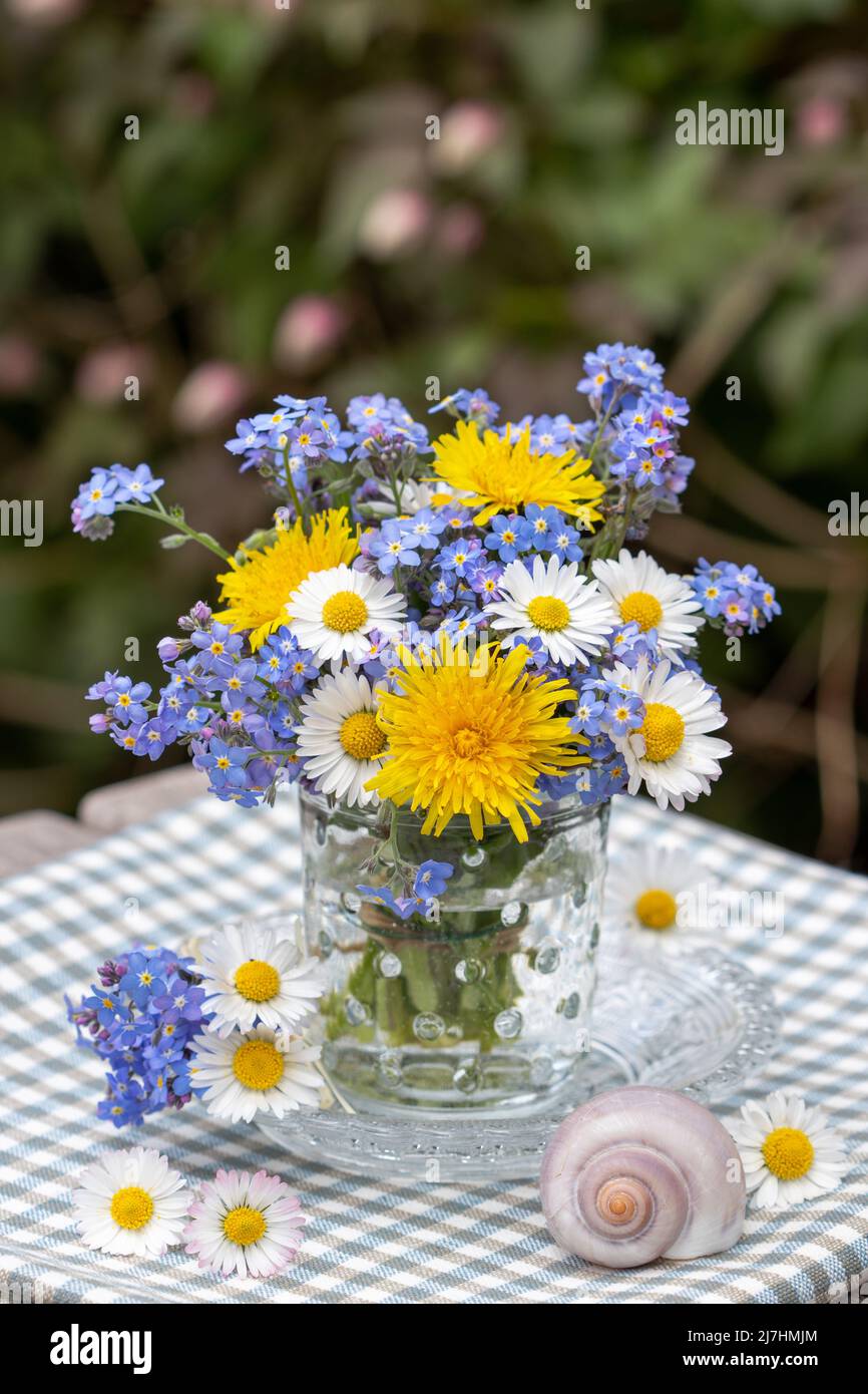 bouquet of dandelions, daisy flowers and forget me not flowers in glass ...