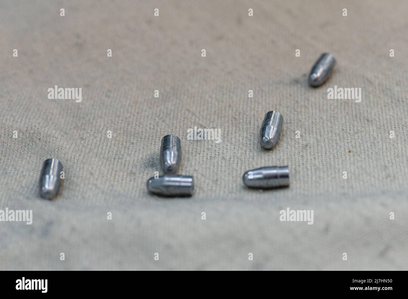 Small caliber bullets on rough fabric at production plant Stock Photo ...