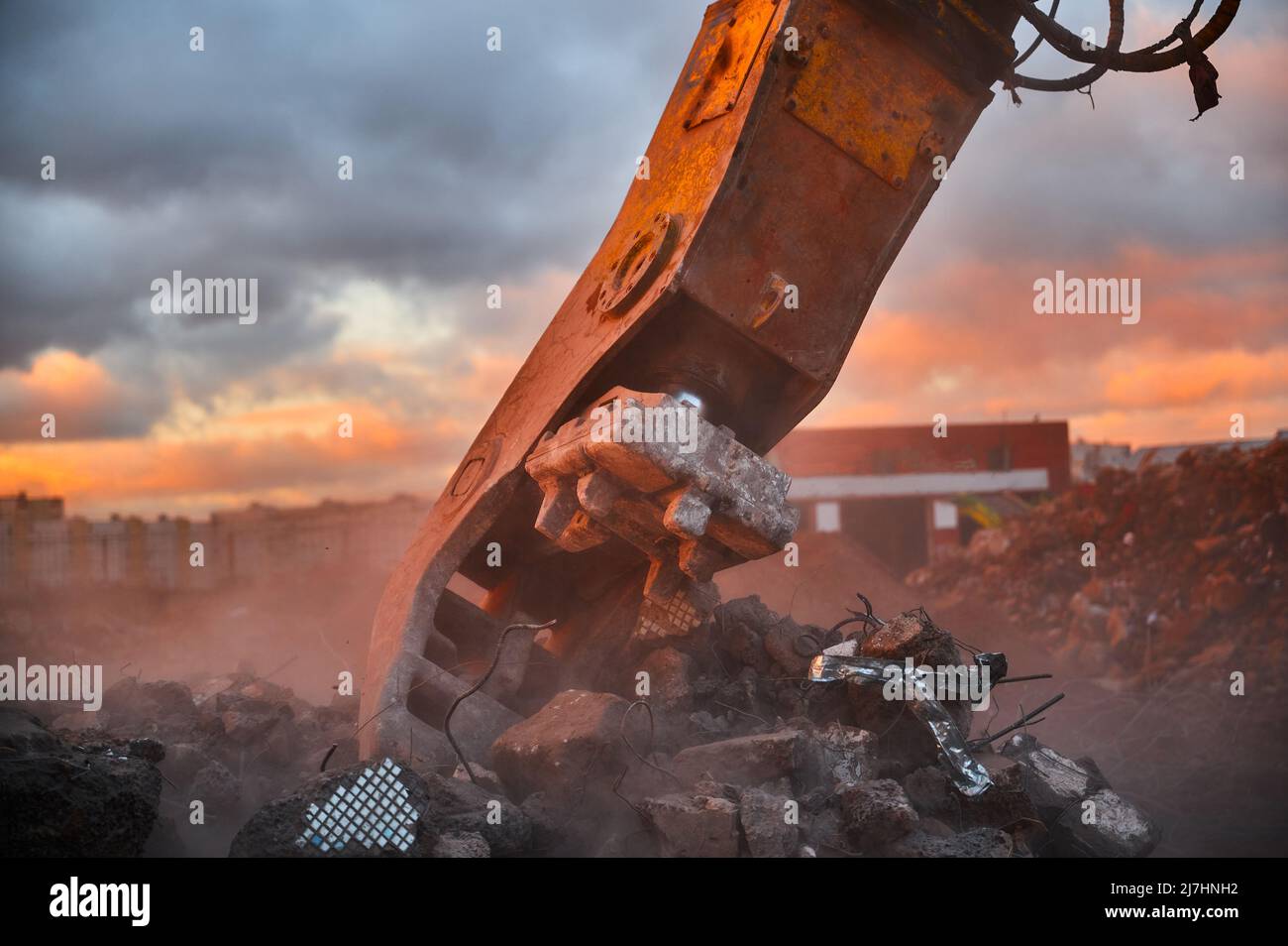 Modern crusher on excavator rigging dismantles concrete beam Stock ...