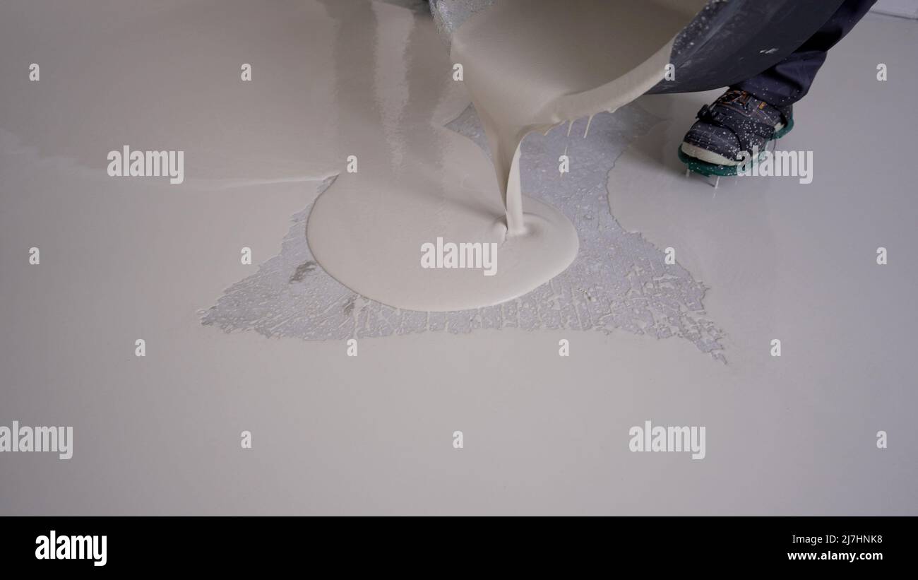 The process of filling the floor. Leveling the floor with a plaster ...