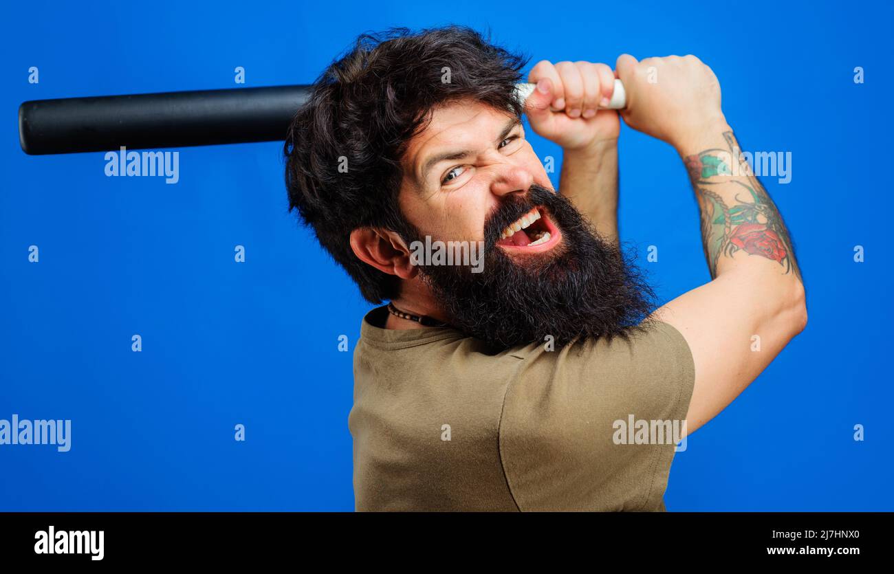 Angry bearded man swinging baseball bat. Sport equipment. Violence ...