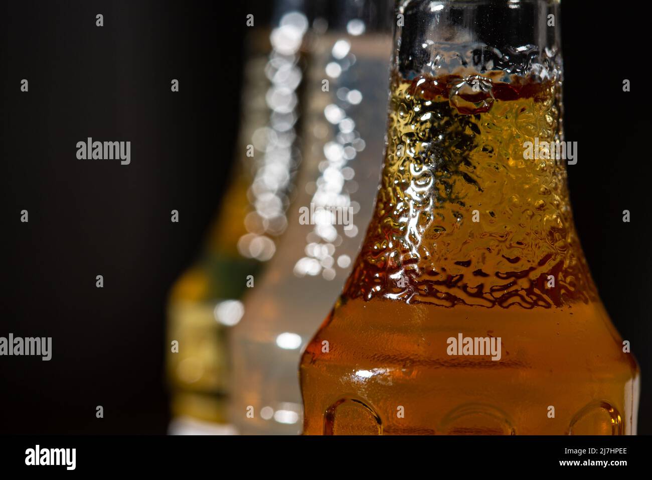 Different alcoholic liquor drink bottles in a row with textured glass ...