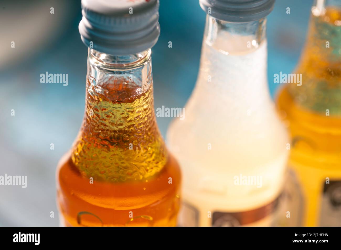 Different alcoholic liquor drink bottles in a row with textured glass ...