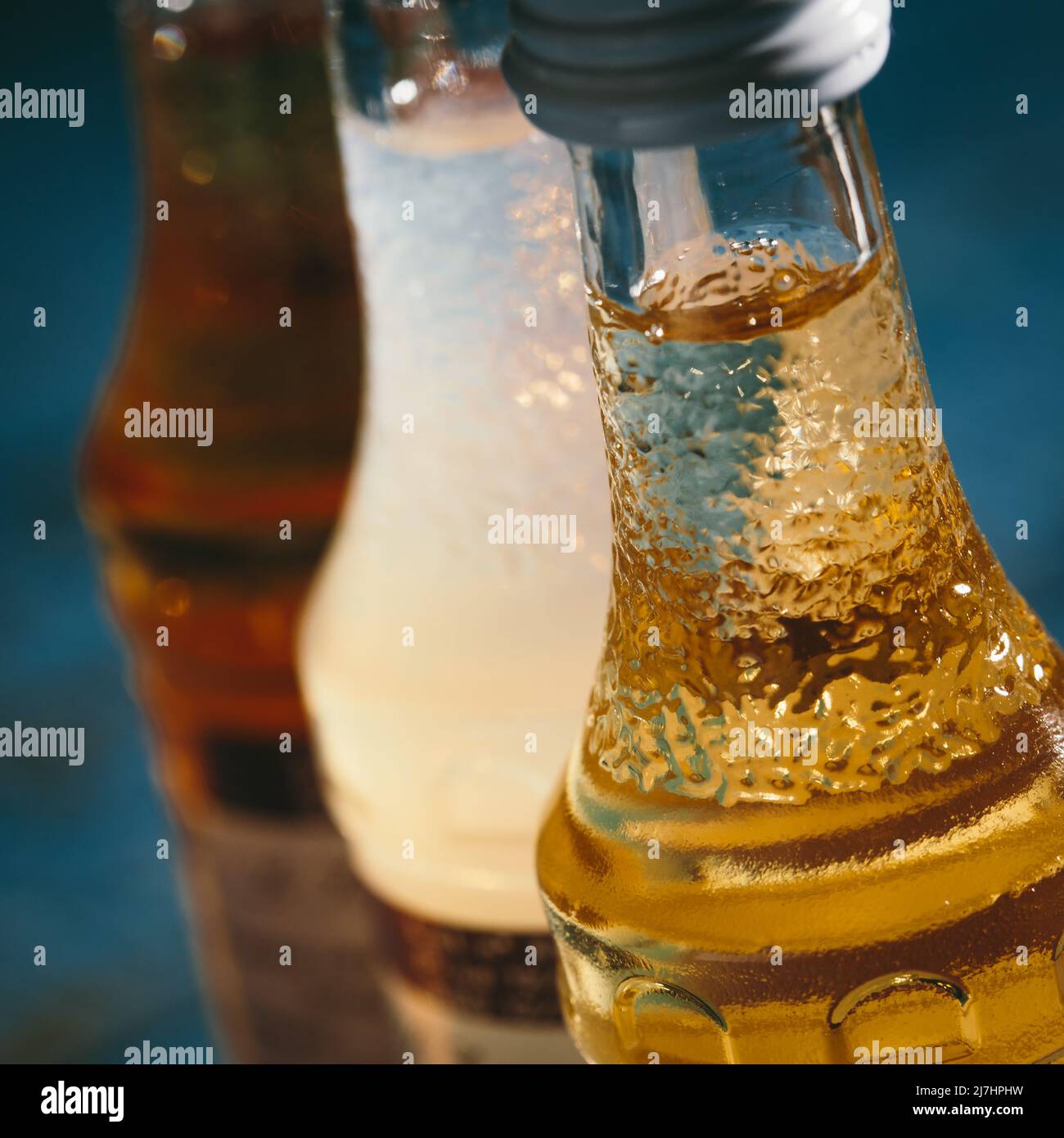 Different alcoholic liquor drink bottles in a row with textured glass ...