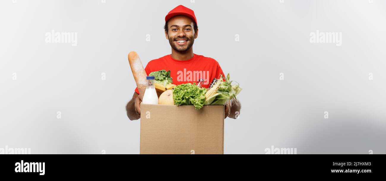 Delivery Concept - Handsome African American delivery man carrying ...