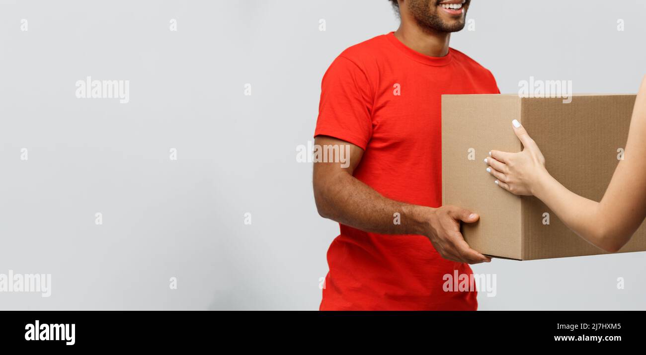 Delivery Concept - Handsome African American delivery man giving ...