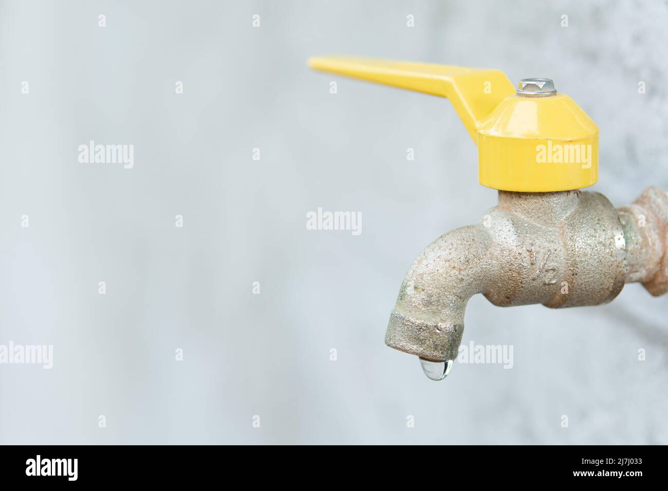 Faucet with a water drop. Old yellow faucet Stock Photo - Alamy