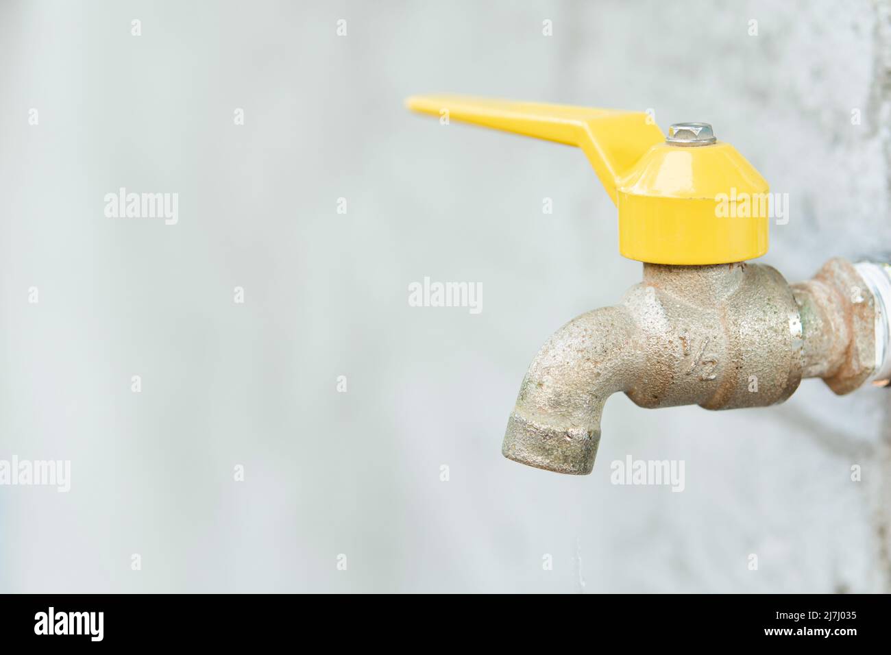 Faucet with a water drop. Old yellow faucet Stock Photo - Alamy