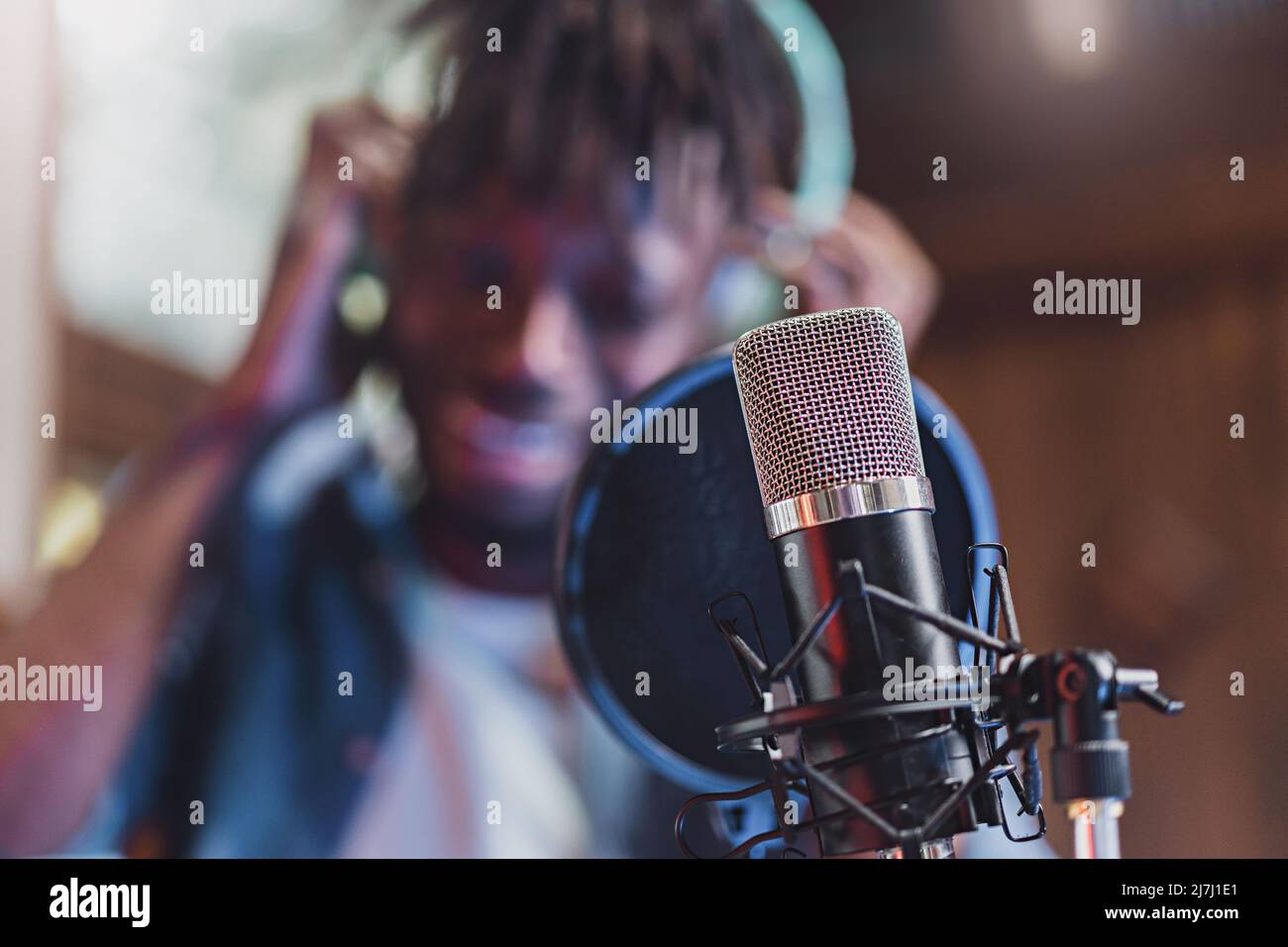 condenser microphone with antipop in front of the blurred face of an ...