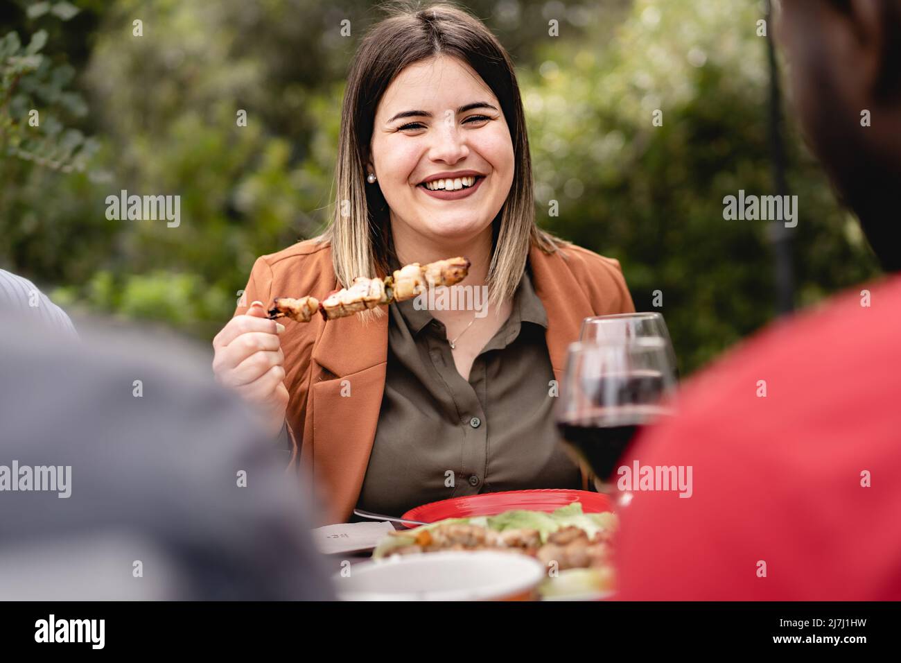 chubby girl smiles and chats with multiethnic group of friends eating ...