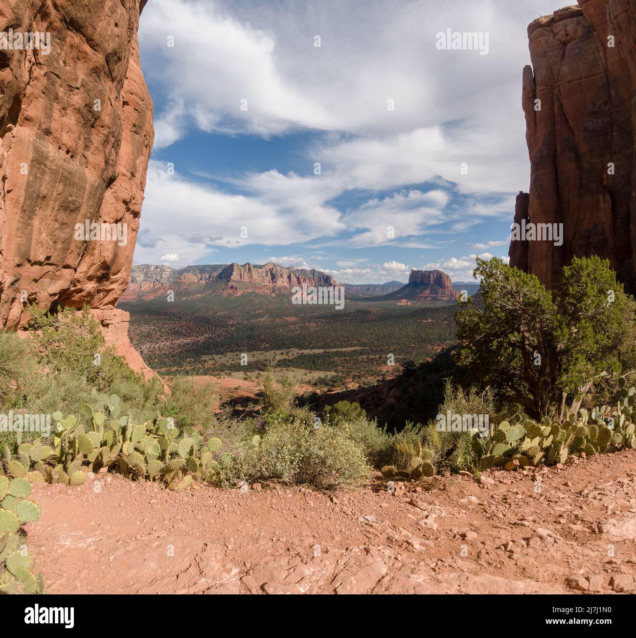 Rock formations to each side with a view of desert valley below and ...