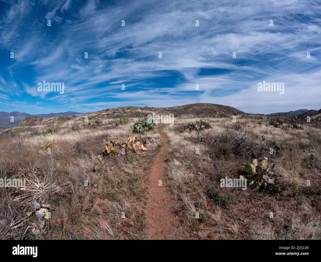 Hiking path going up a desert mountain with a cloudy sky Stock Photo ...
