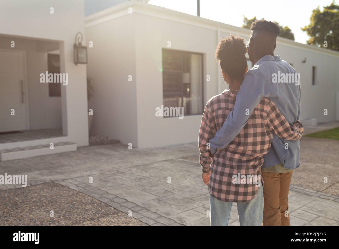 Rear view of african american young woman embracing young boyfriend ...