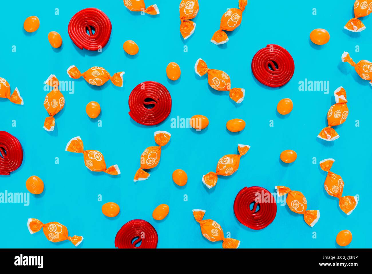 Candy, orange candies and red swirls on blue background. assortment of ...
