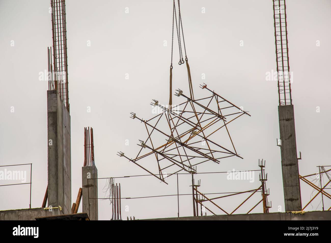 A high-rise construction crane lifts the lattice structure into the ...