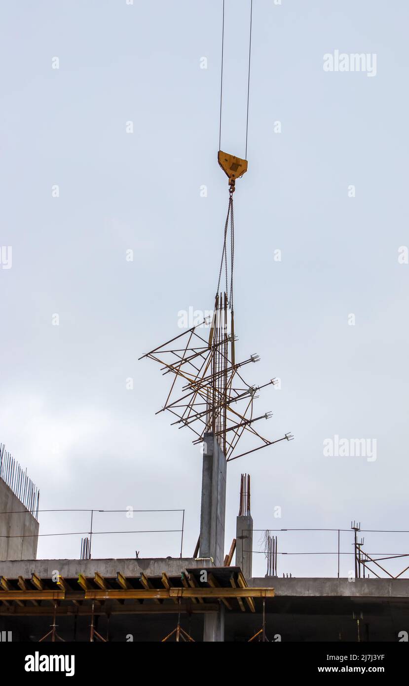 A high-rise construction crane lifts the lattice structure into the ...