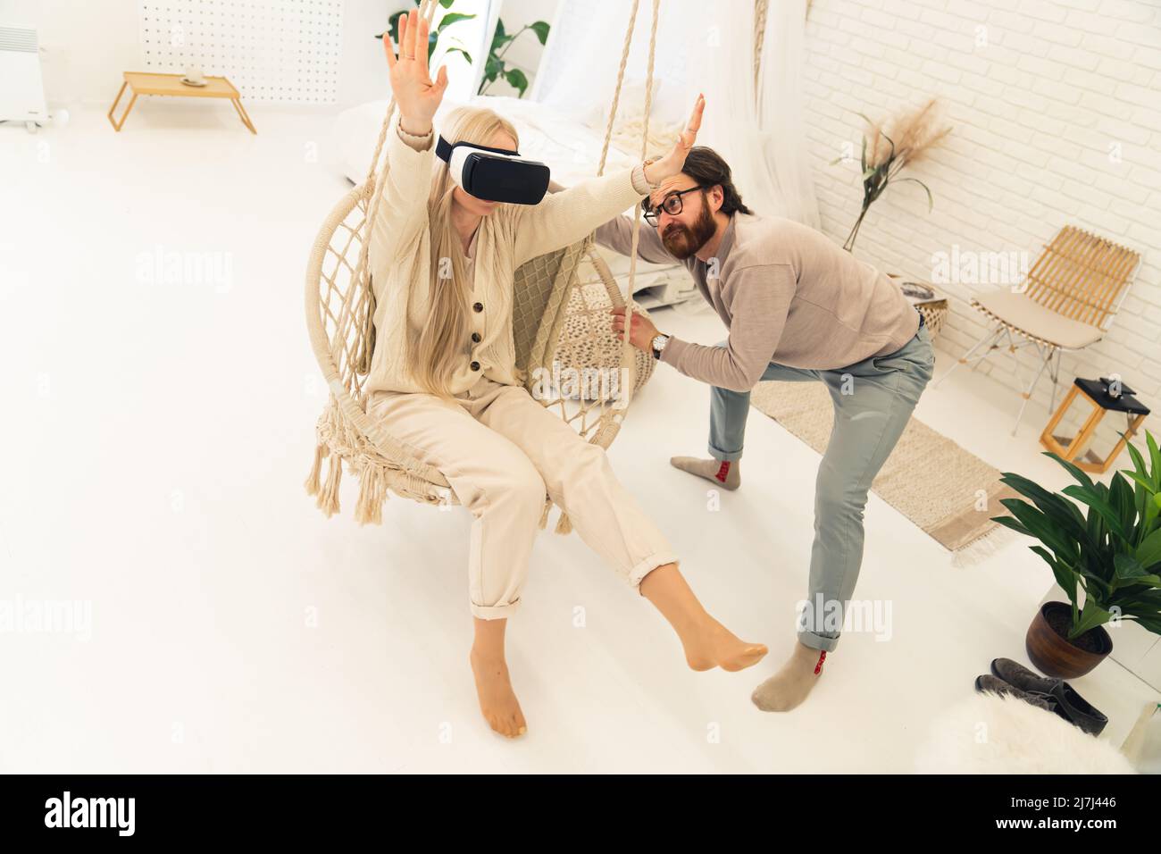 Young couple in a minimalistic light apartment wearing casual clothes ...