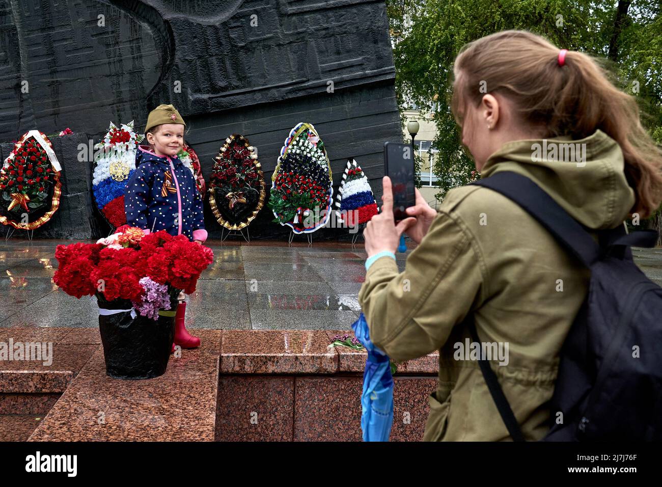 A woman takes pictures of her kid near the Monument of Glory on the ...