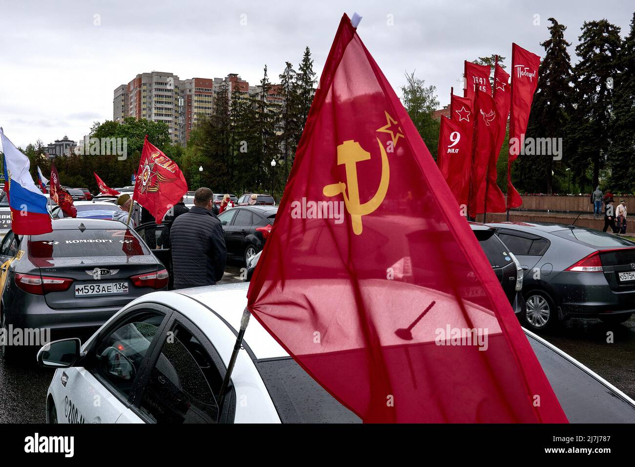 People hold out flags with Soviet symbols from their cars near the ...