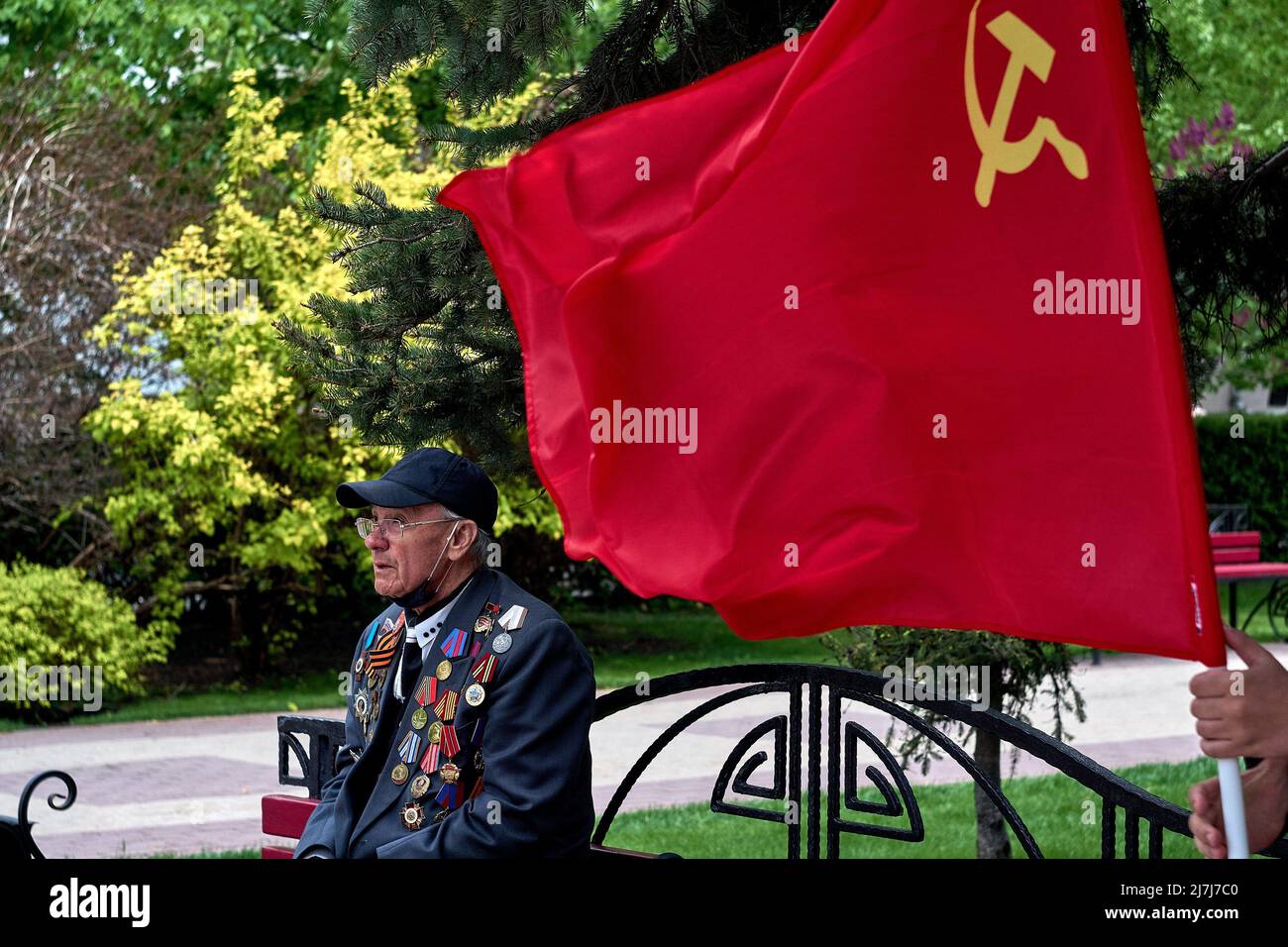 An elderly man with military awards under the Soviet flag on the 77th ...