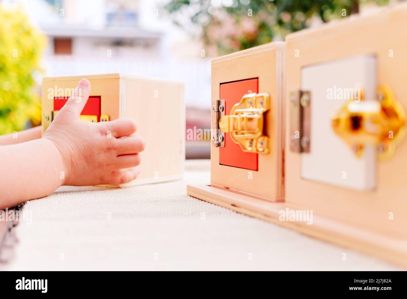 Little girl plays with a montessori educational material to open and ...