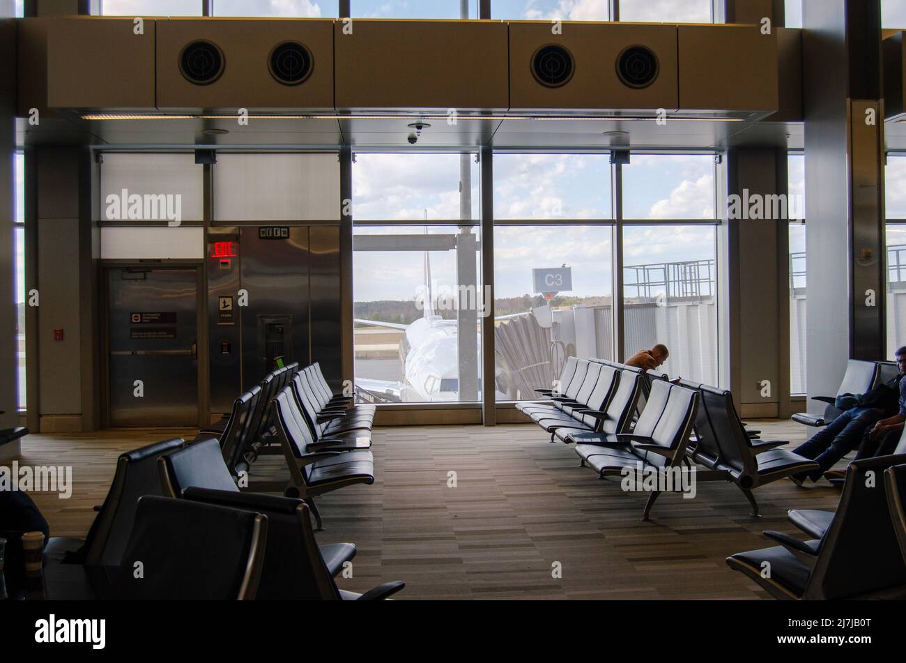 Empty airport seats in the waiting terminal with airplane parked ...