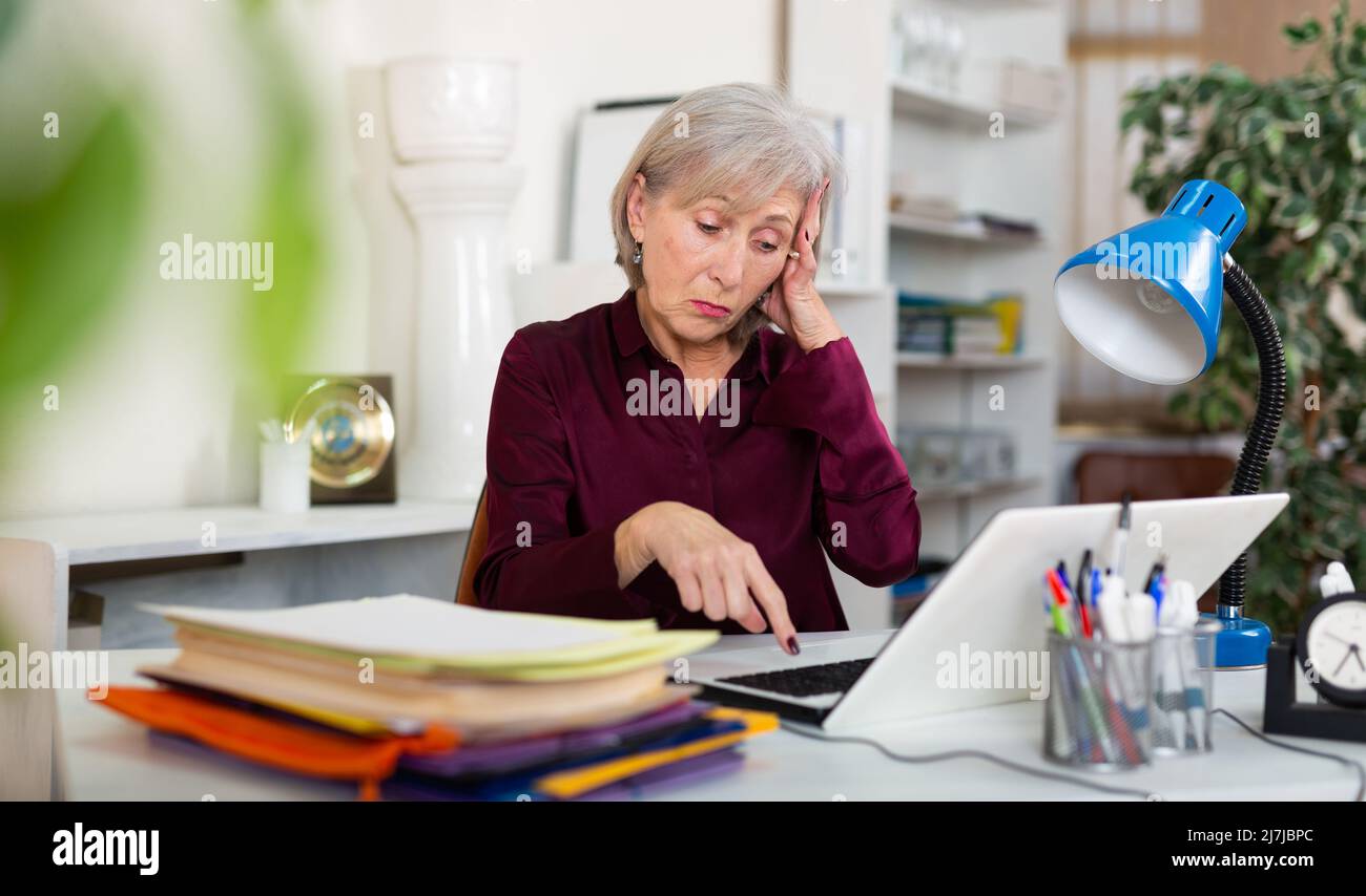 Stressed mature woman working in office Stock Photo - Alamy