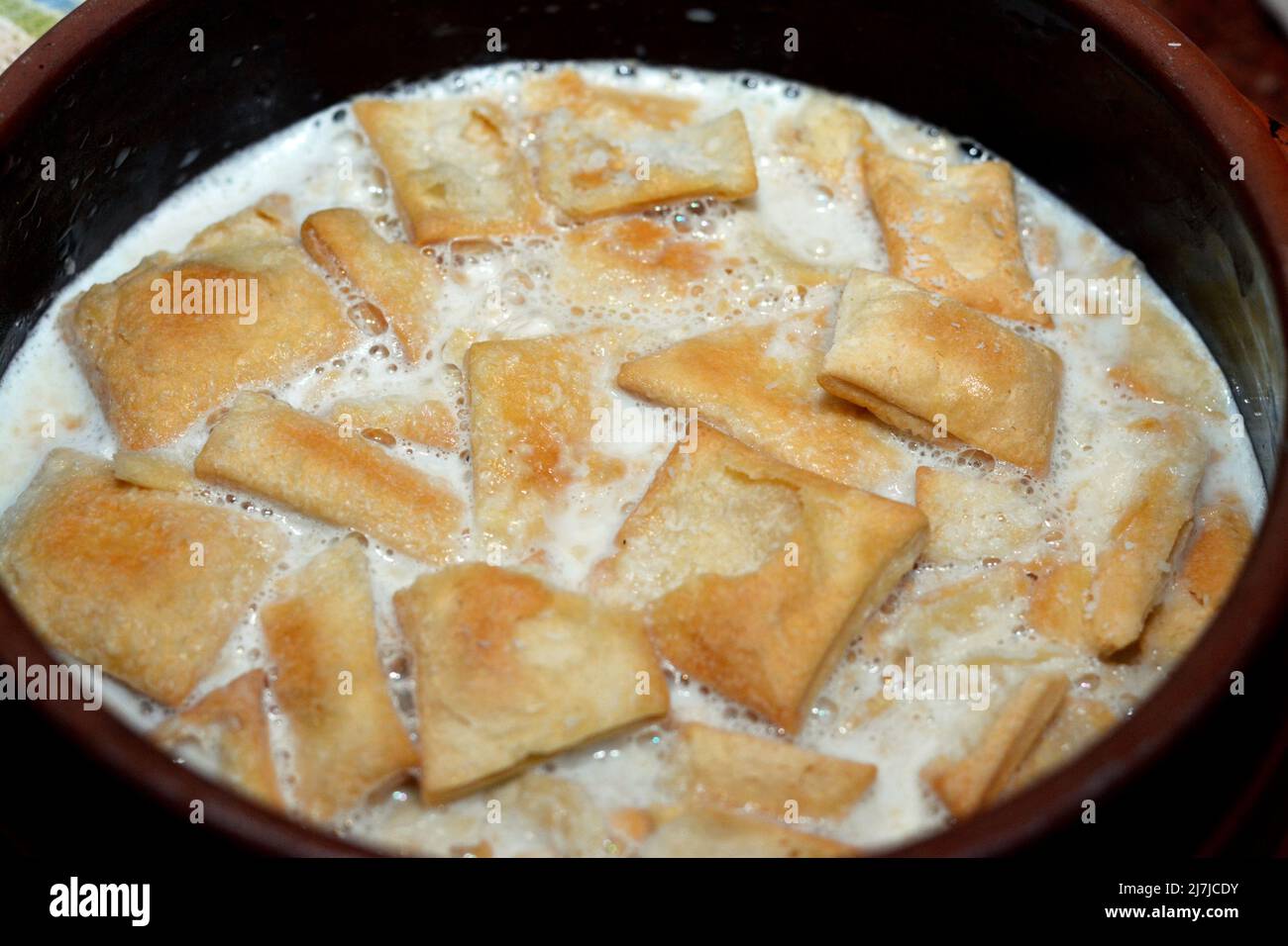 Milk on Egyptian bread pudding in a brown bowl pottery casserole made ...