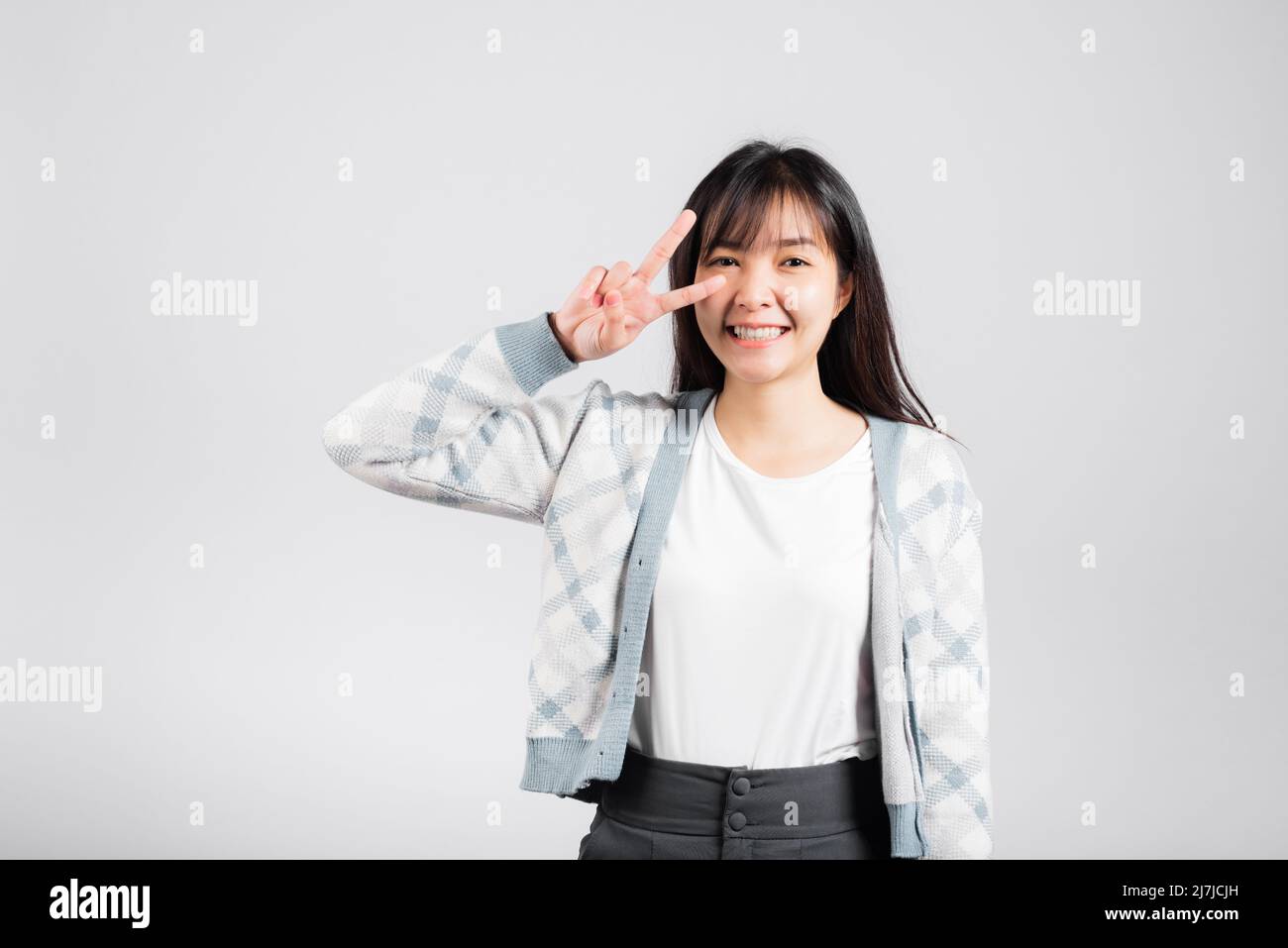 Woman showing finger making v-sign victory symbol near eye looking to ...