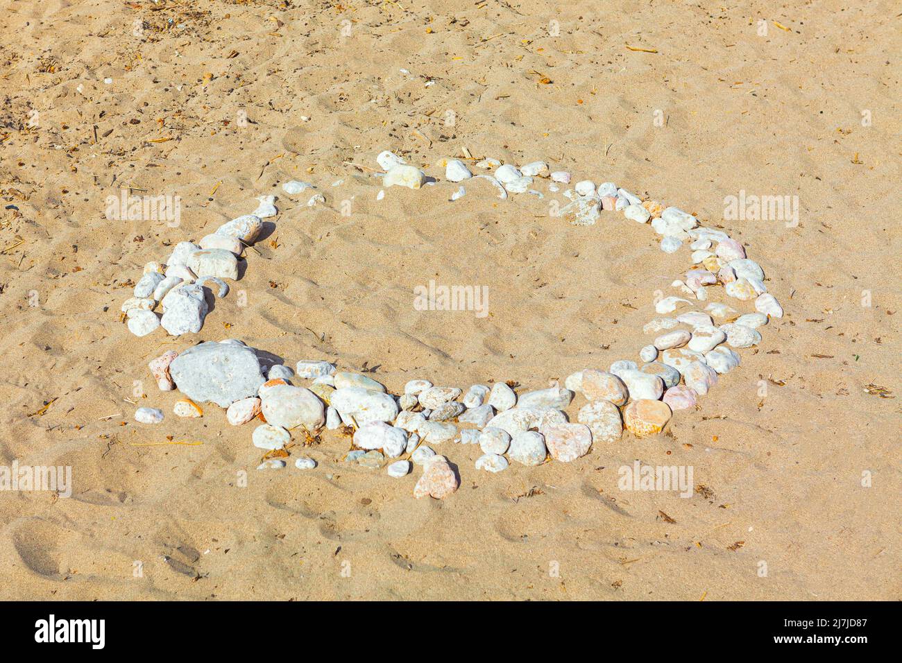 Circle made by stones on the sandy beach Stock Photo - Alamy