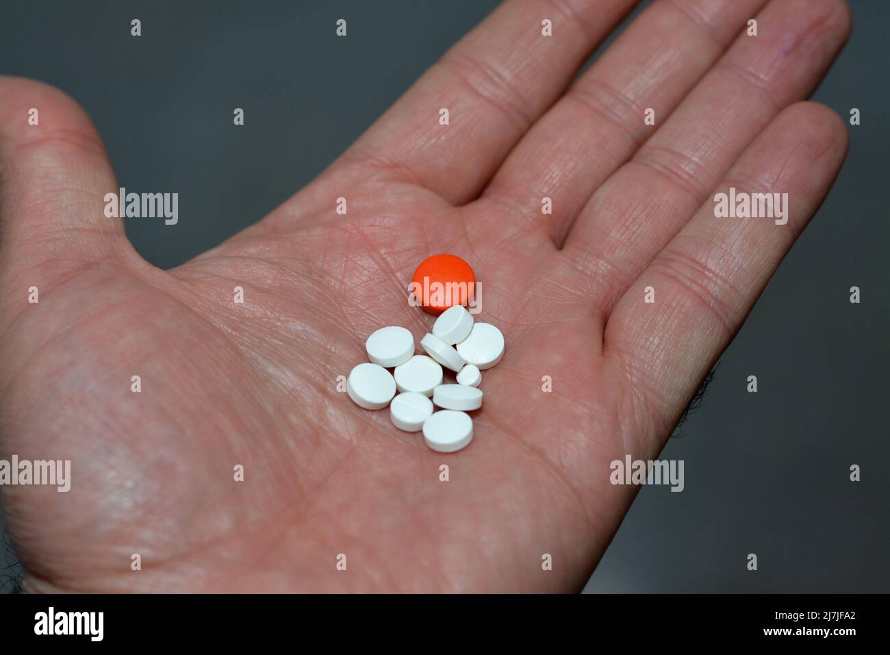 Male hand holding pills, colorful pills, drugs, vitamins in man's hand ...