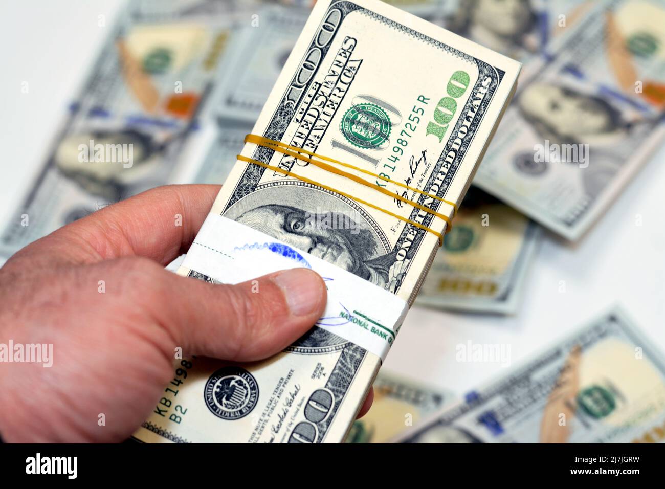 man hand holding a stack of 100 one hundred American dollars banknotes ...