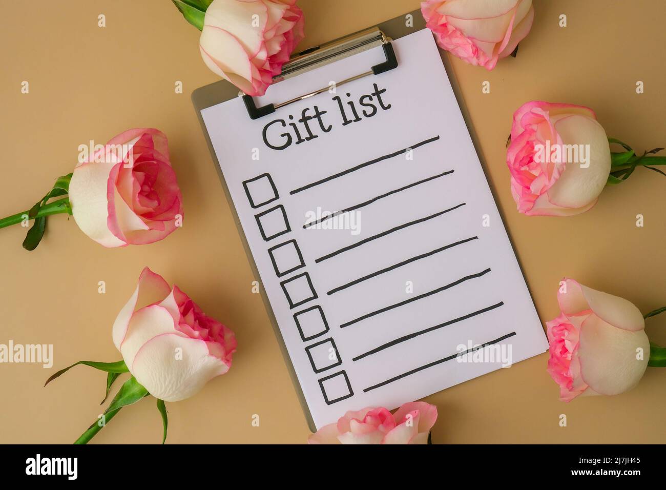 GIFT LIST text on paper note. Delicate pink roses on beige background ...