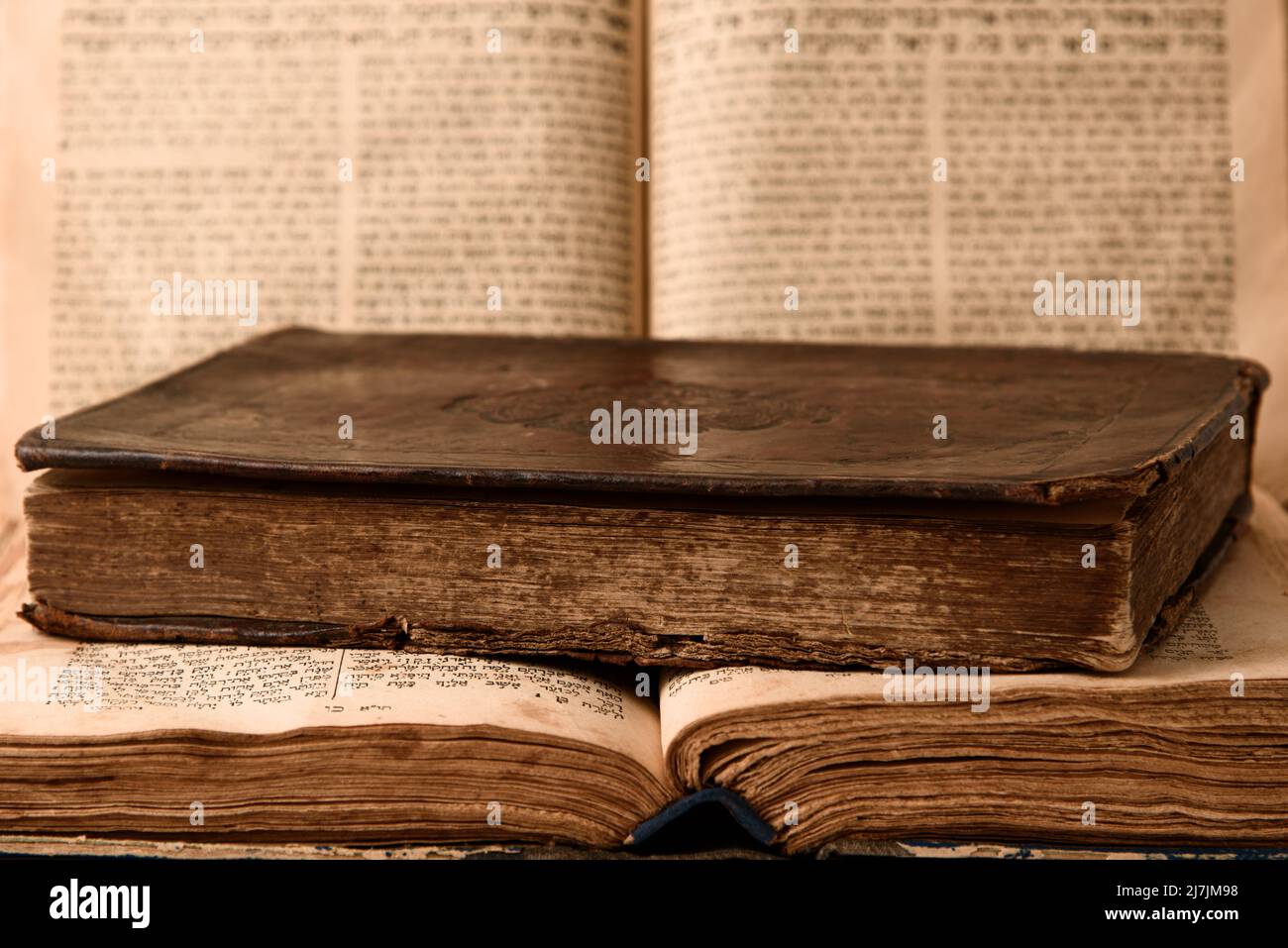 Old worn shabby jewish books in leather binding and open blurred Torah ...