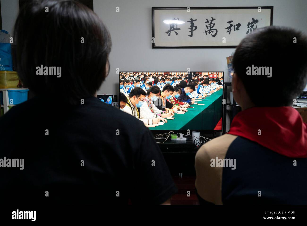 SHANGHAI, CHINA - MAY 10, 2022 - Two citizens watch a live TV broadcast ...
